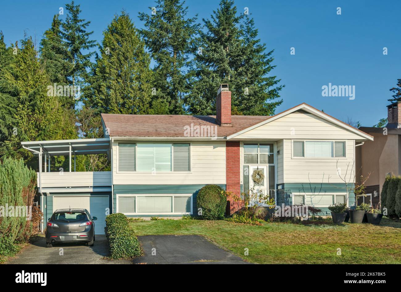 Inexpensive residential house with grey car parked on the driveway ...