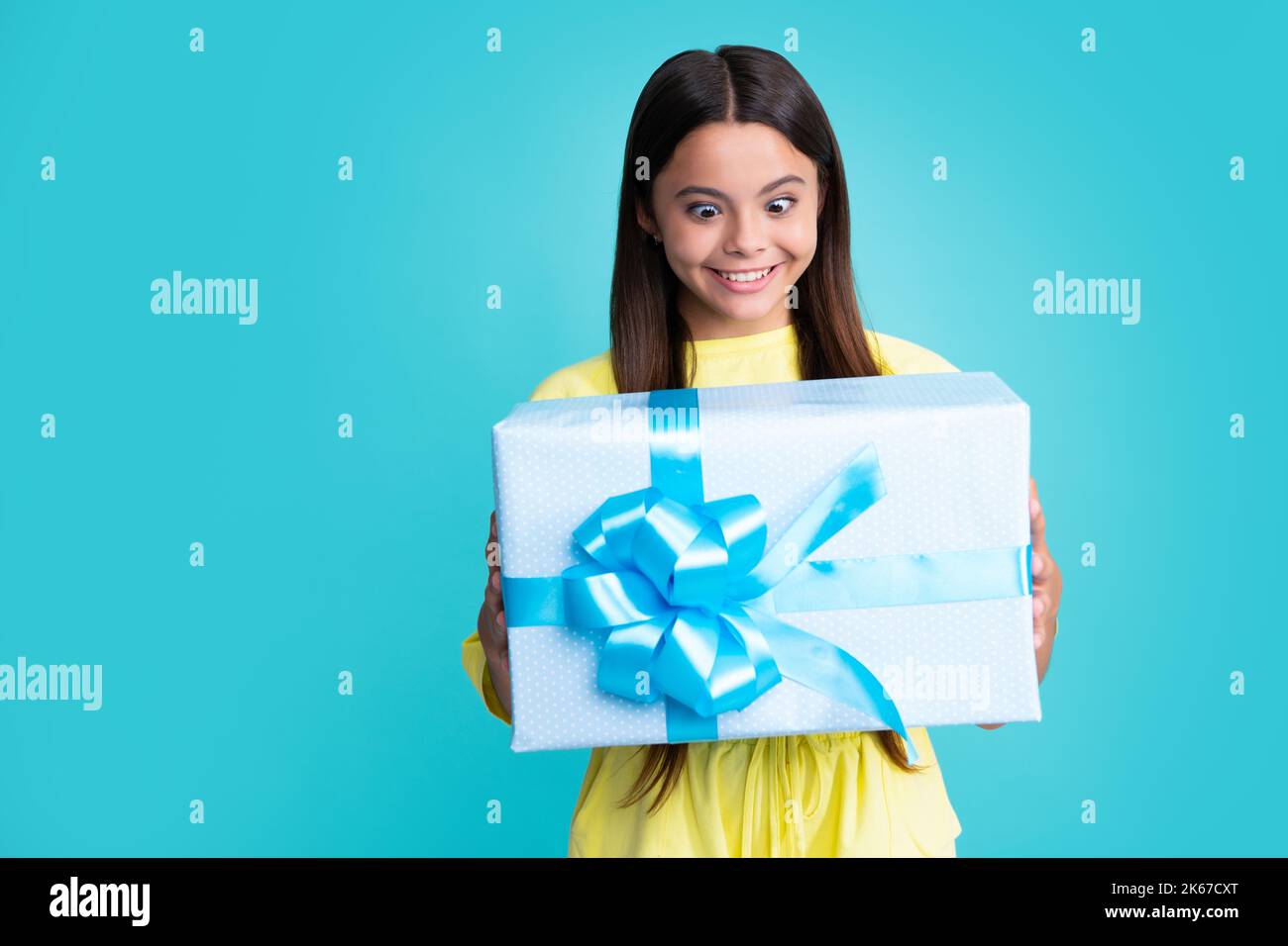 Teenager kid with present box. Teen girl giving birthday gift. Present, greeting and gifting ...