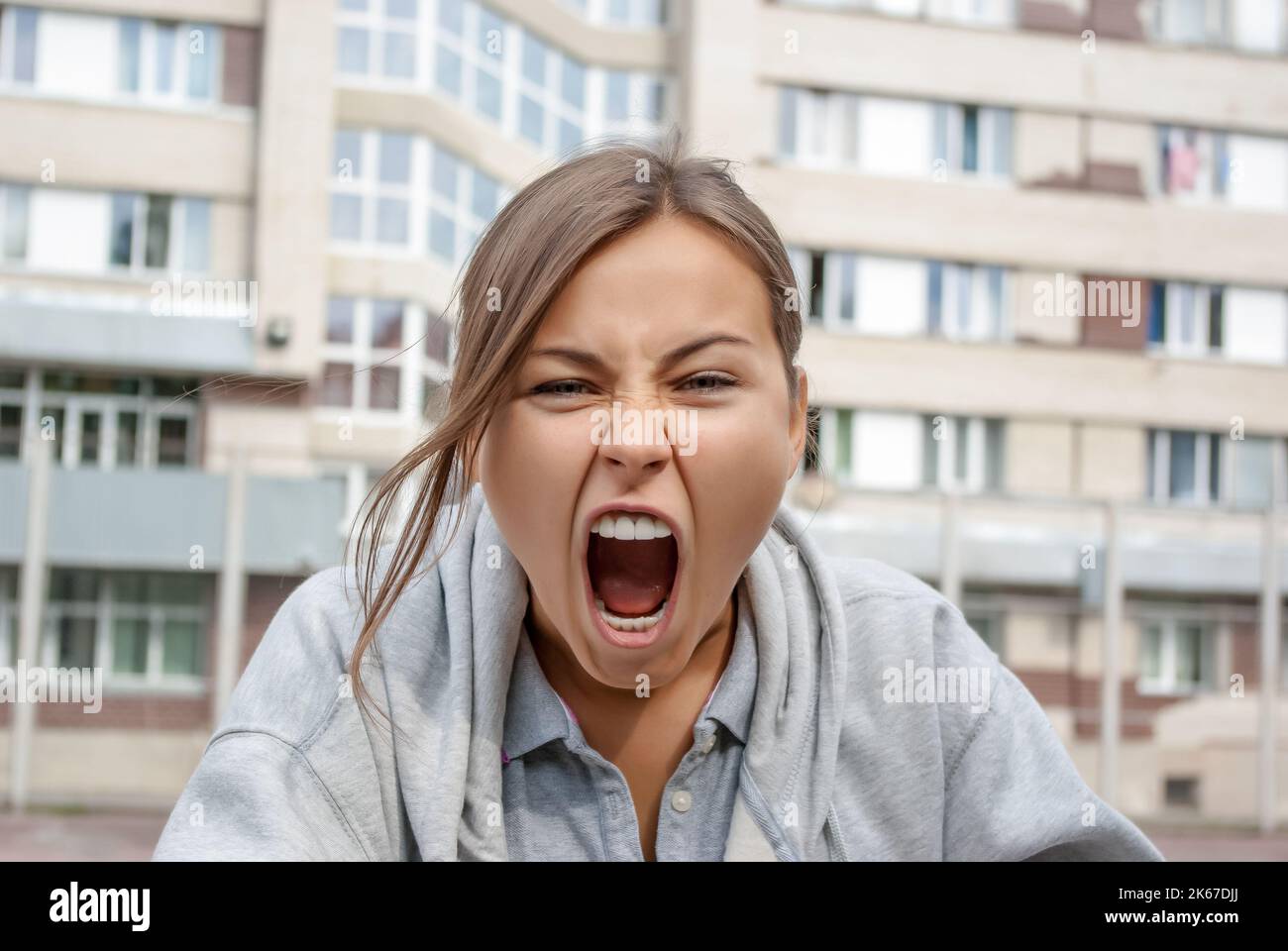 Cheerful young girl. Makes funny facial expression Stock Photo - Alamy