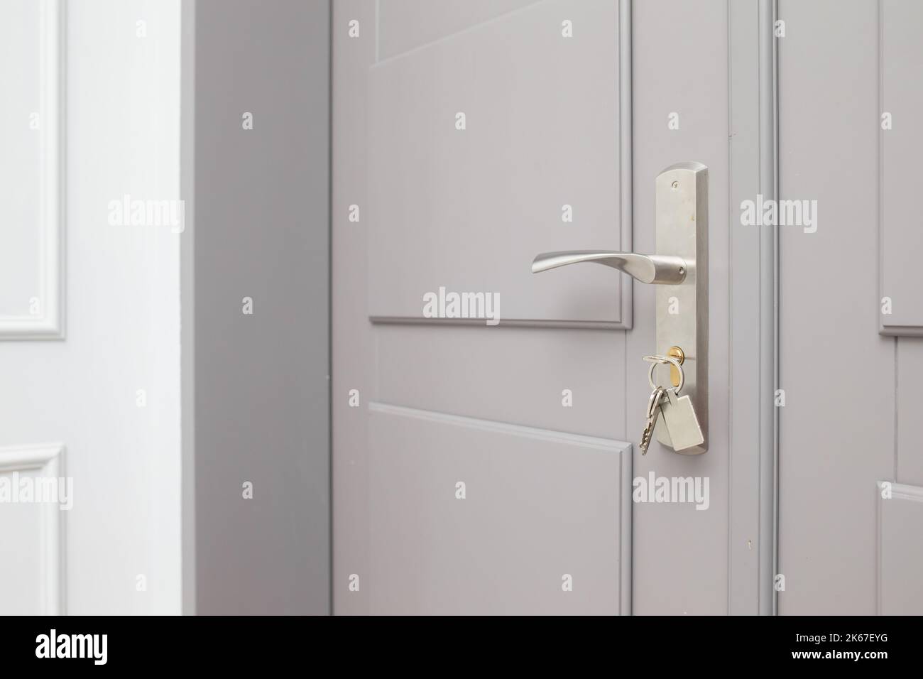 Keys in modern gray door locked for safety Stock Photo - Alamy