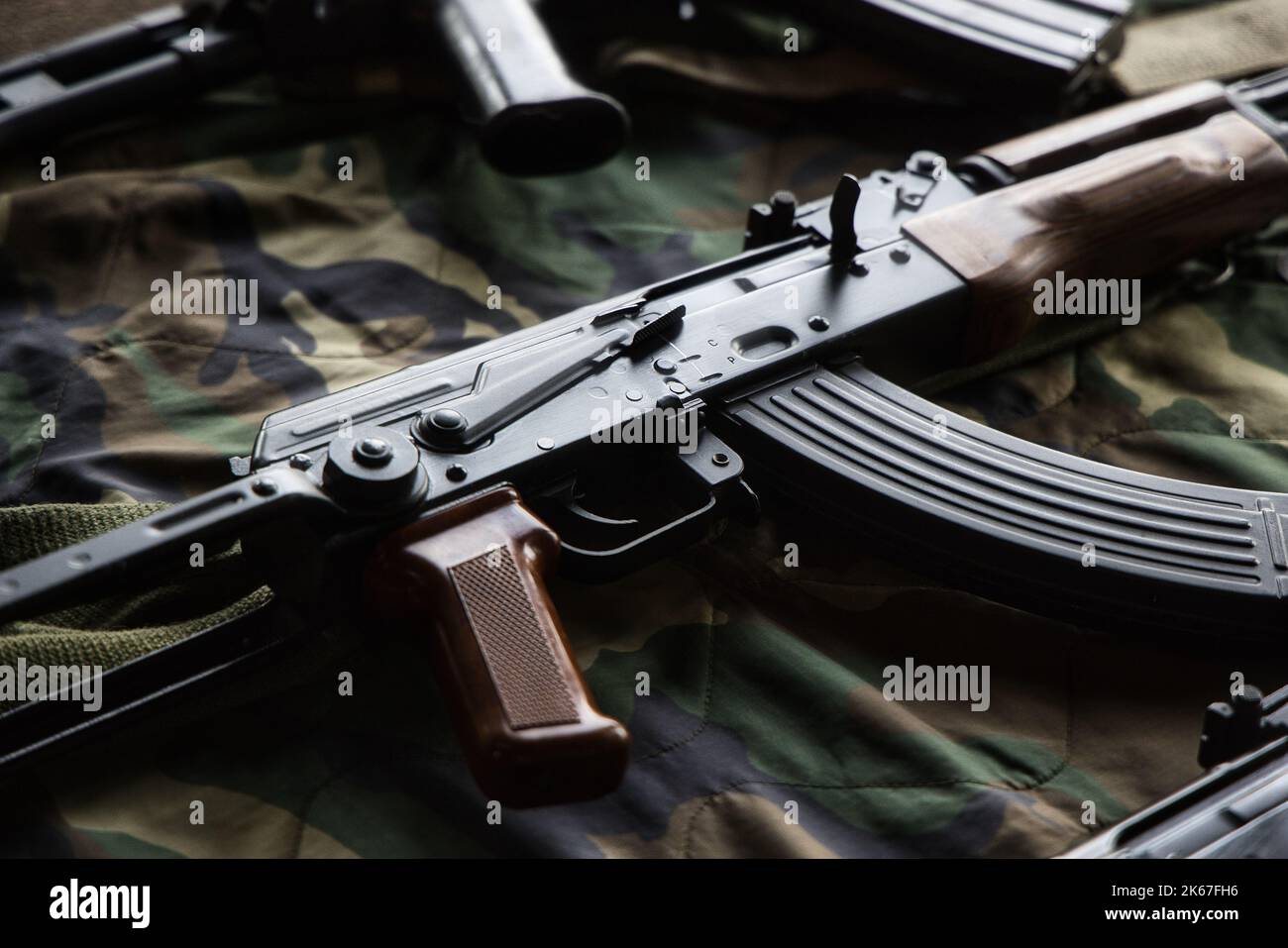 A close up of an AK47 firearm on a camouflage pattern fabric Stock ...