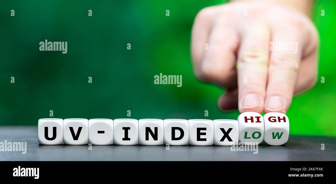 Hand turns dice and changes the expression 'uv-index low' to 'uv-index ...