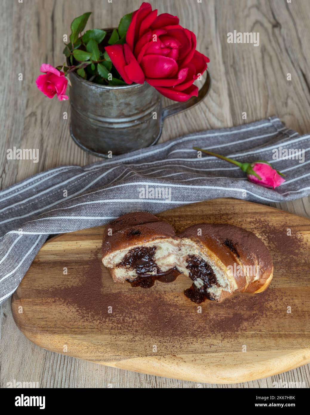 A croissant split in two with a liquid chocolate filling inside and red ...