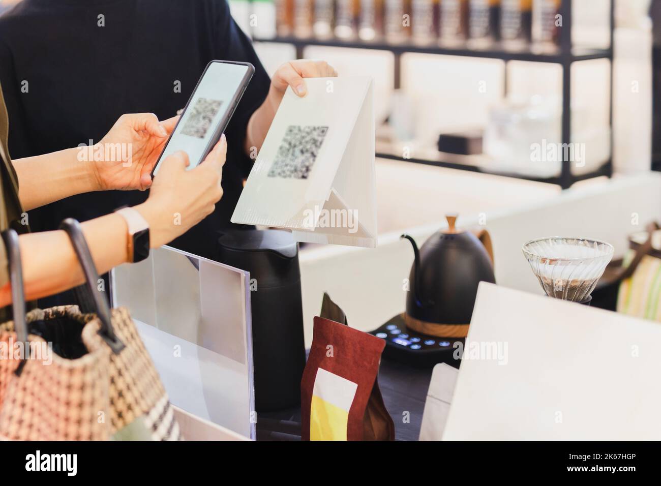 Women customer paying by QR code scanning on mobile phone at shop Stock ...
