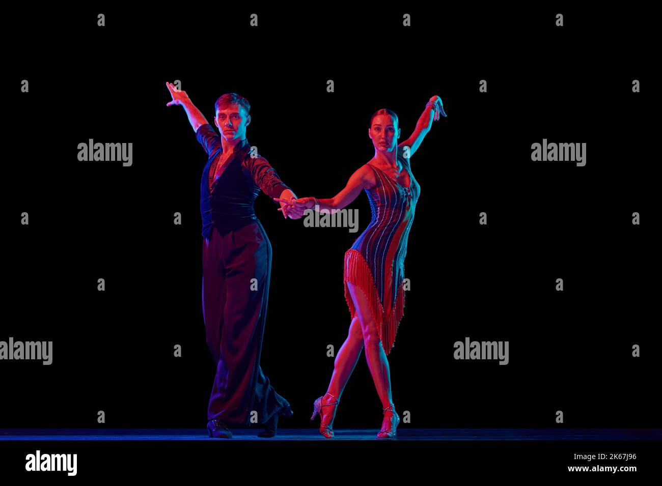 Stylish ballroom dancers couple in gorgeous outfits dancing in sensual ...
