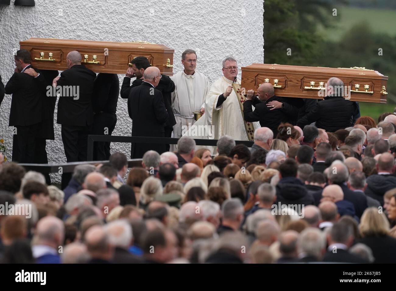 Priest Fr John Joe Duffy (centre right) sprinkles holy water on the ...