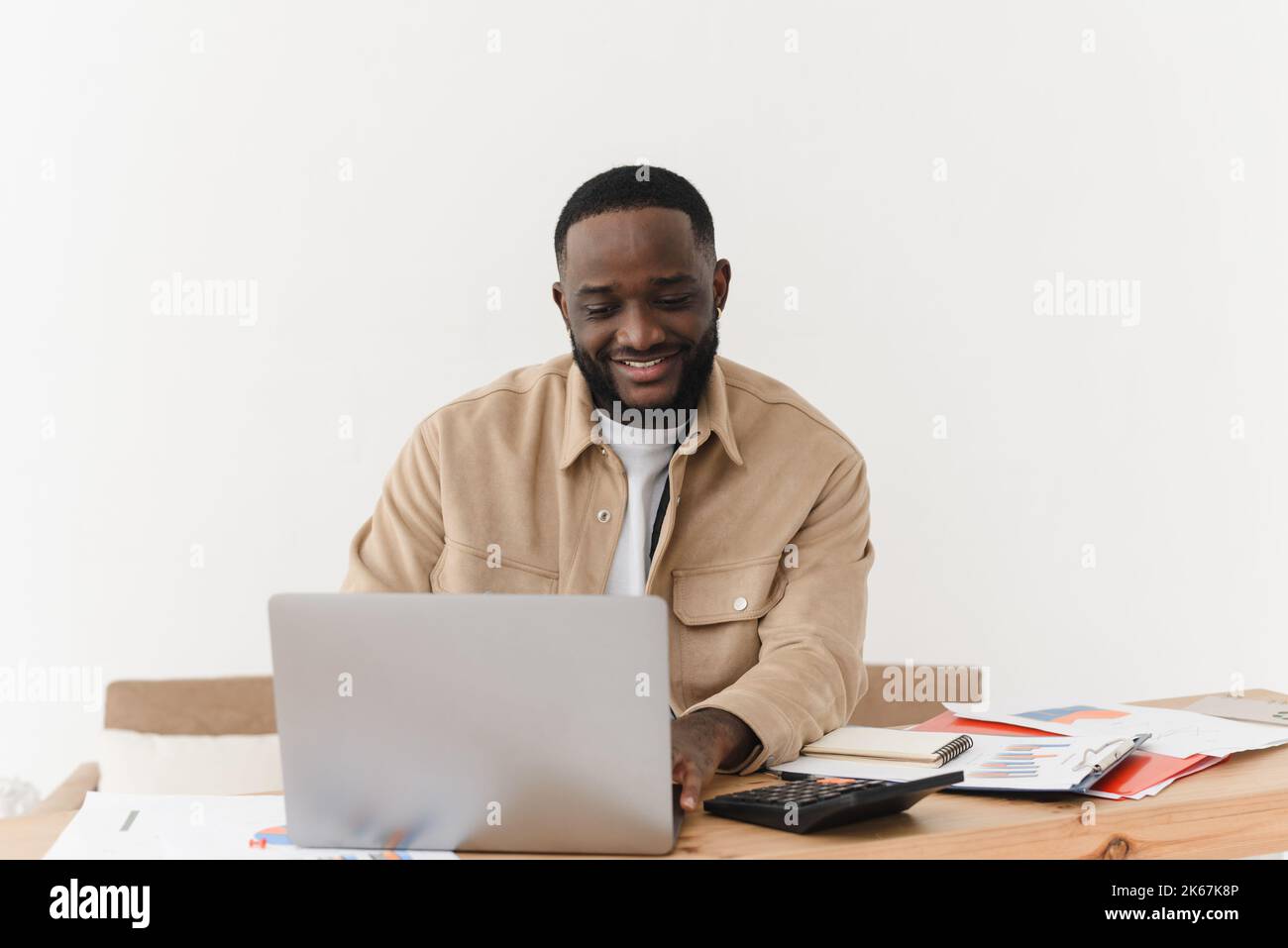 Smilling young afro american man counting expenses and keeping records ...