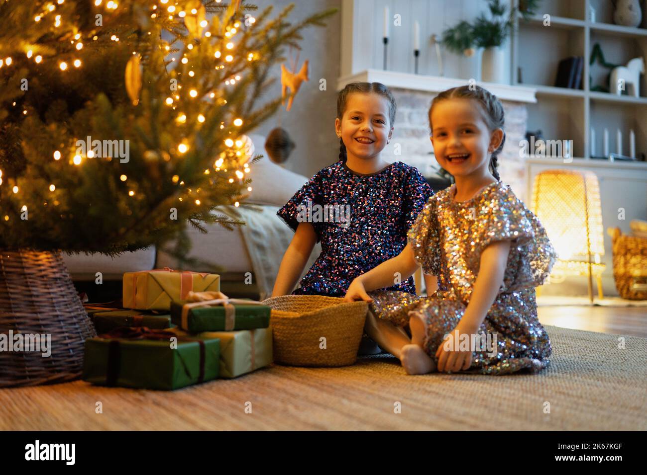 Two cute little girls under Christmas tree. Children under Christmas ...
