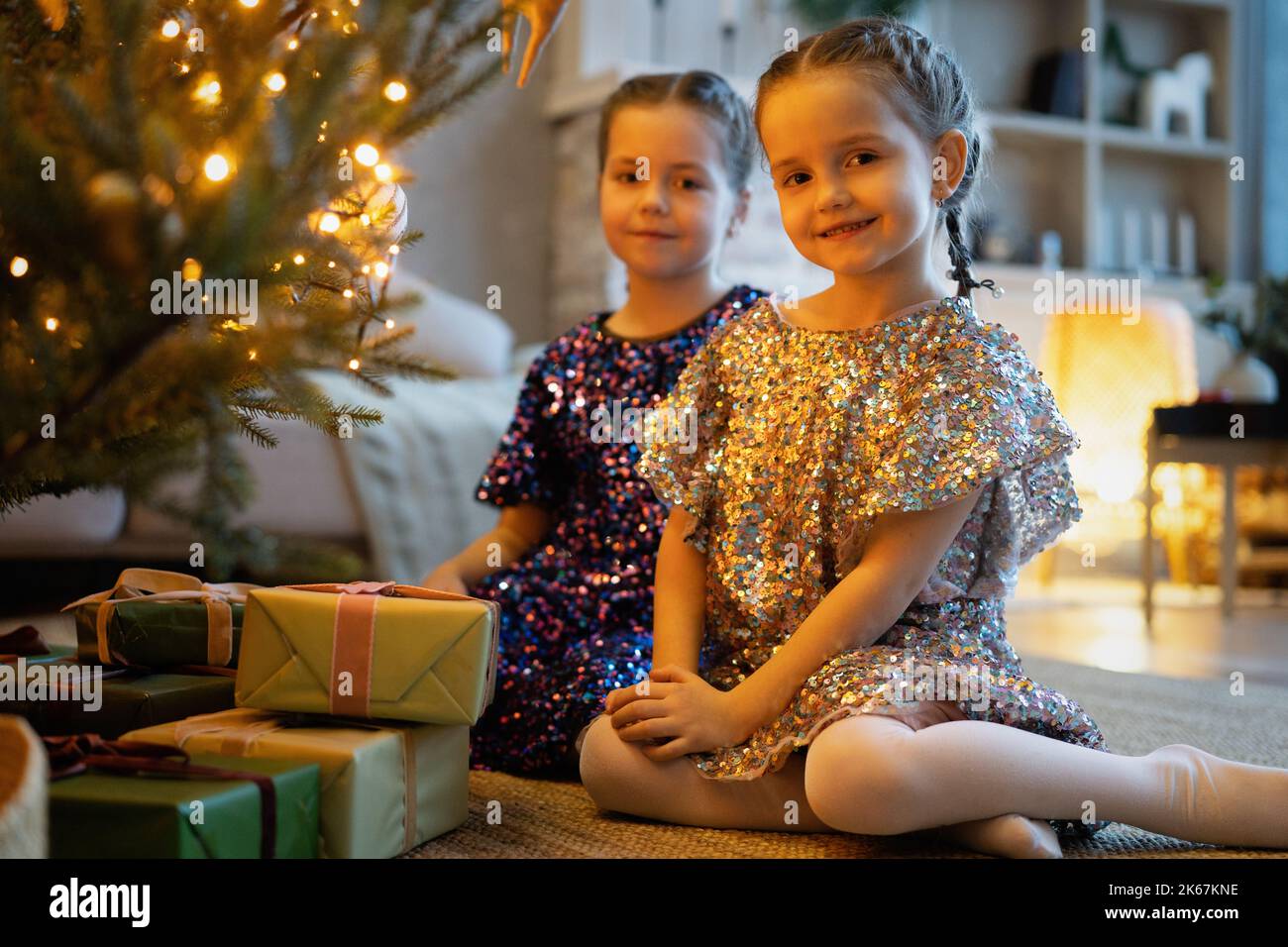 Two cute little girls under Christmas tree. Children under Christmas ...