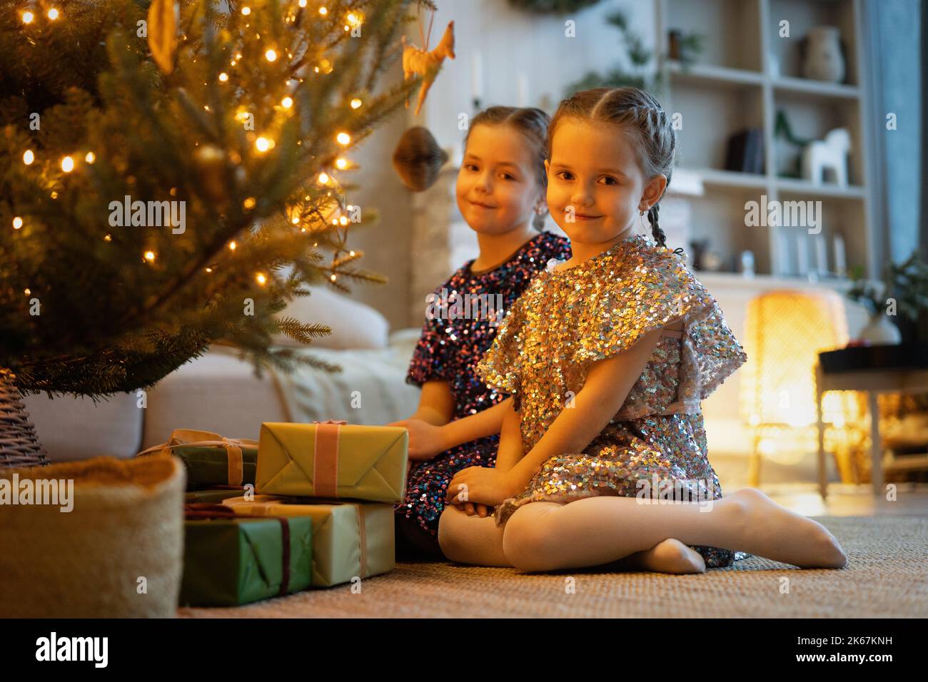 Two cute little girls under Christmas tree. Children under Christmas ...