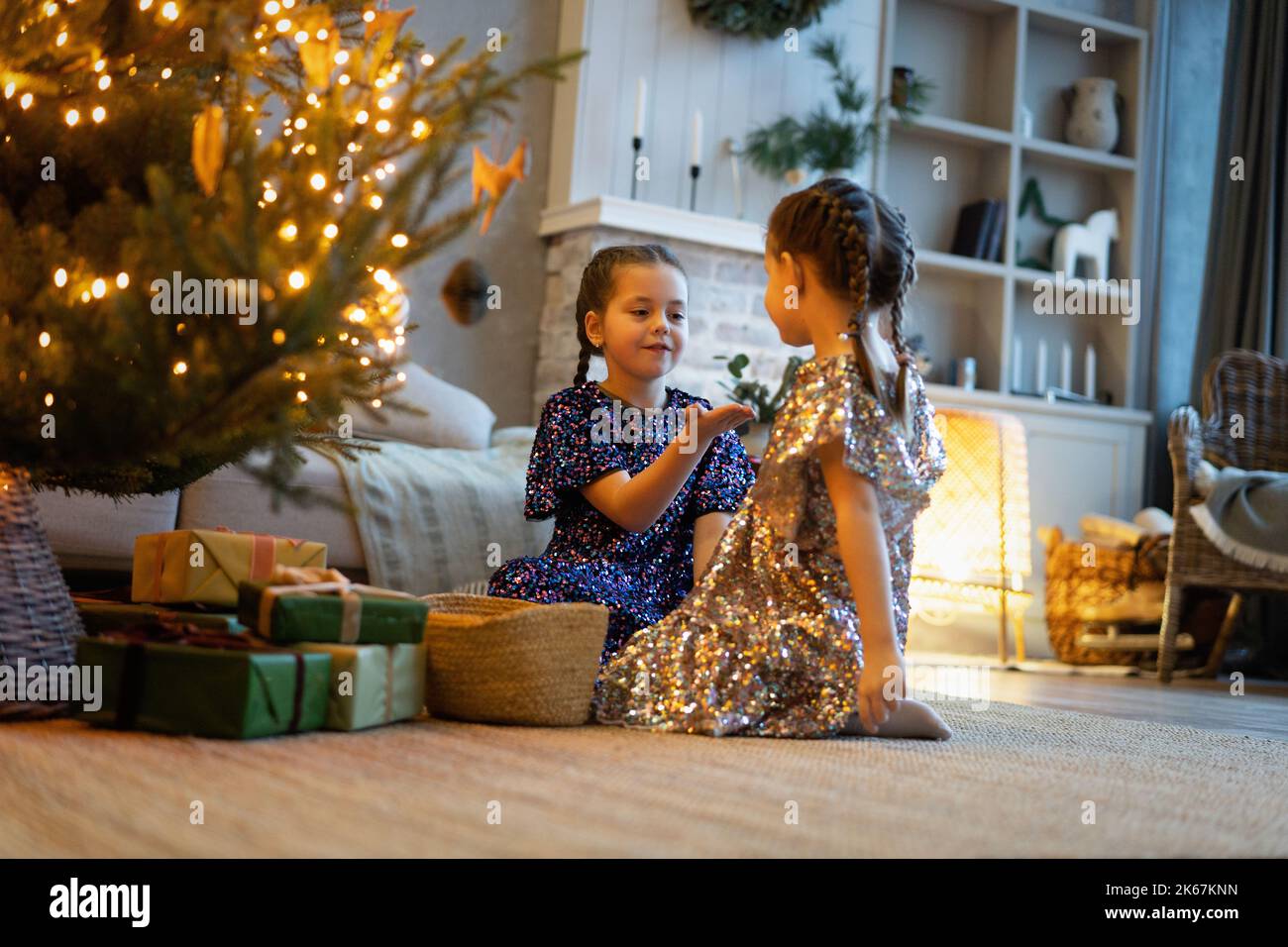 Two cute little girls under Christmas tree. Children under Christmas ...
