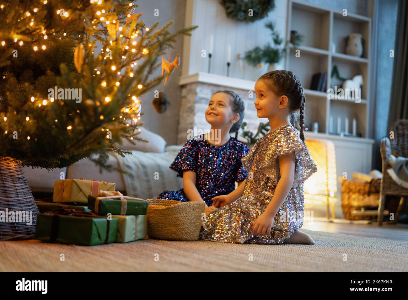 Two cute little girls under Christmas tree. Children under Christmas ...