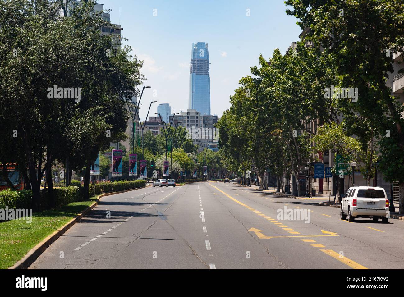 A clean road with trees leading to Costanera norte skyscraper in ...
