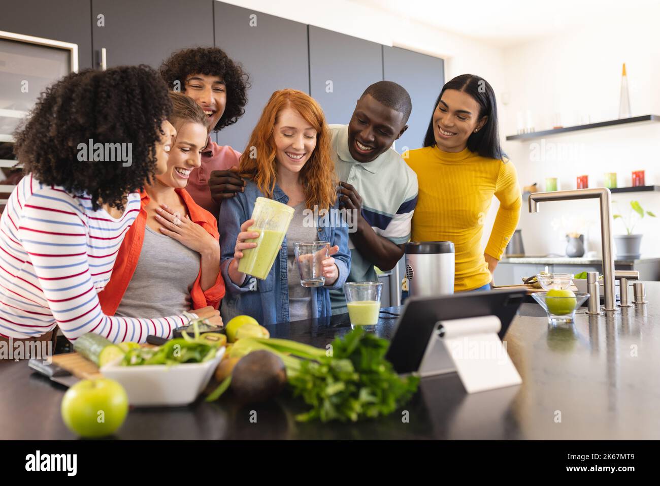 Happy diverse friends making healthy drink together in kitchen Stock ...