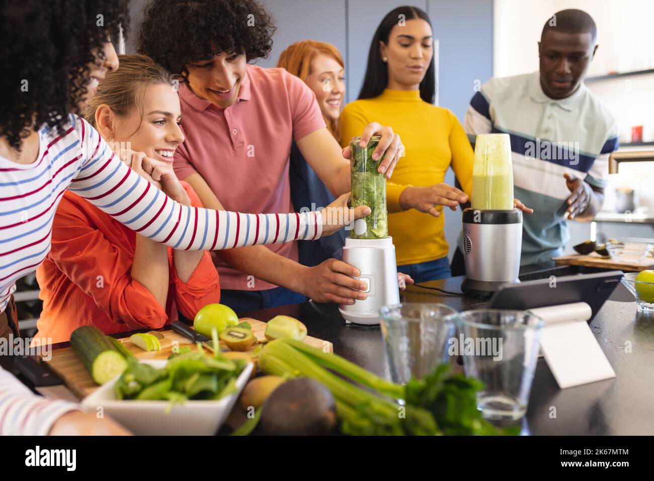 Happy diverse friends making healthy drink together in kitchen Stock ...