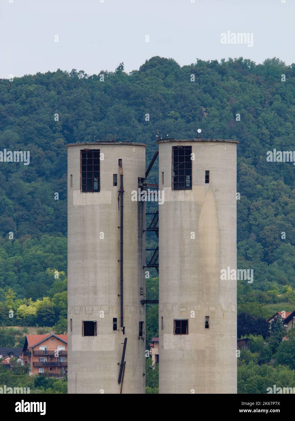 A vertical shot of two tall factory chimneys with a background of a ...