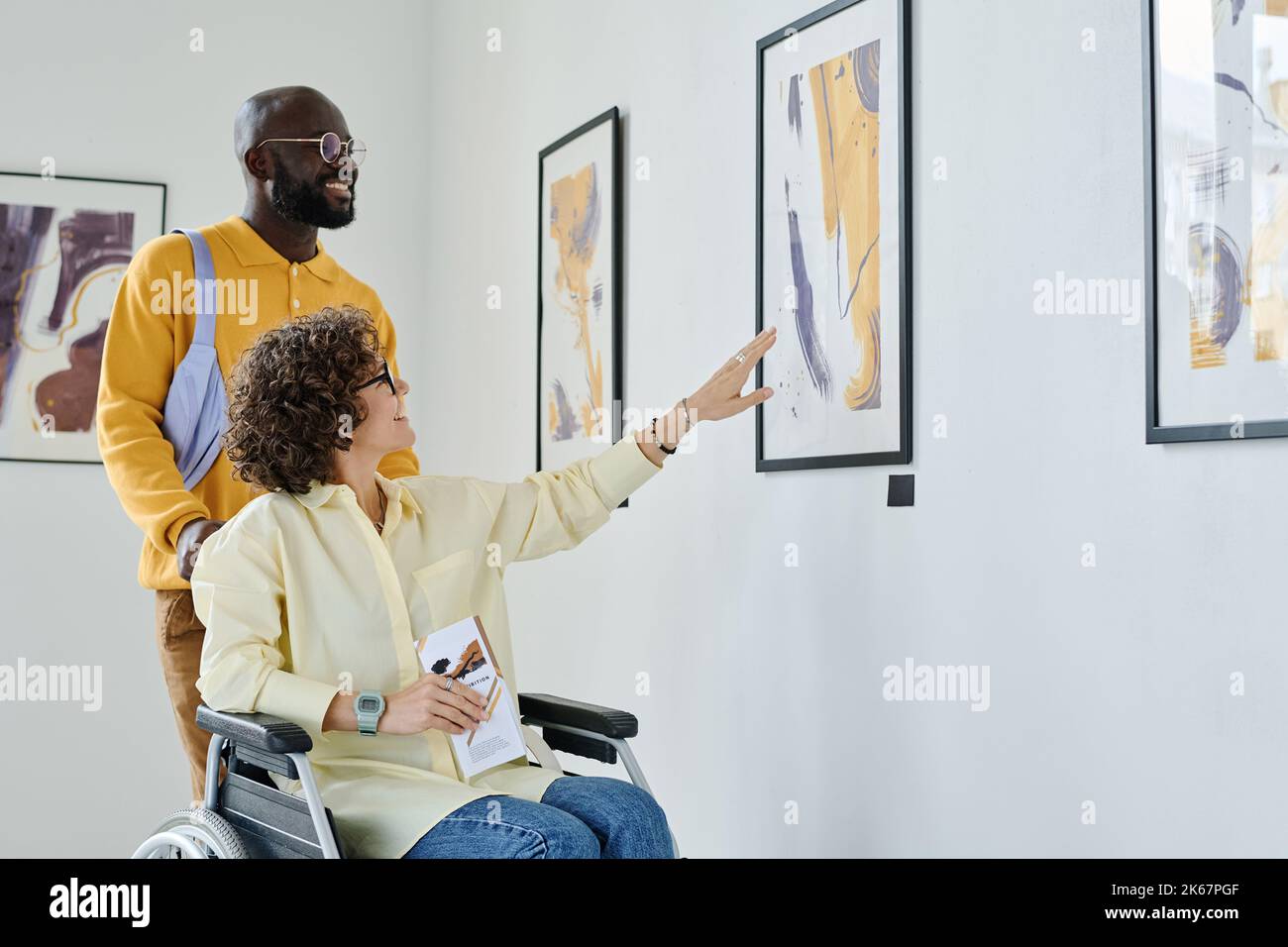Happy woman with disability visiting art gallery with young man Stock ...