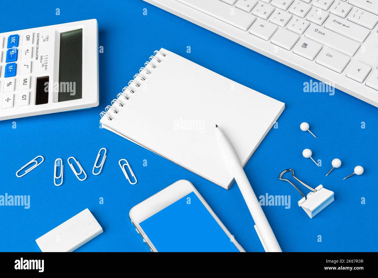 Flat lay, top view of blue office table desk. Workspace with blank note ...