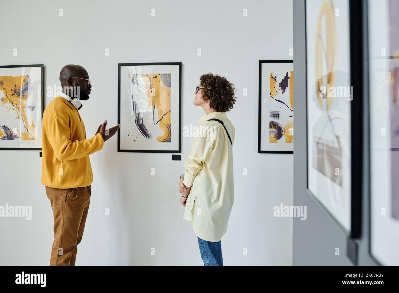 Multiethnic couple discussing modern art together during exhibition at ...
