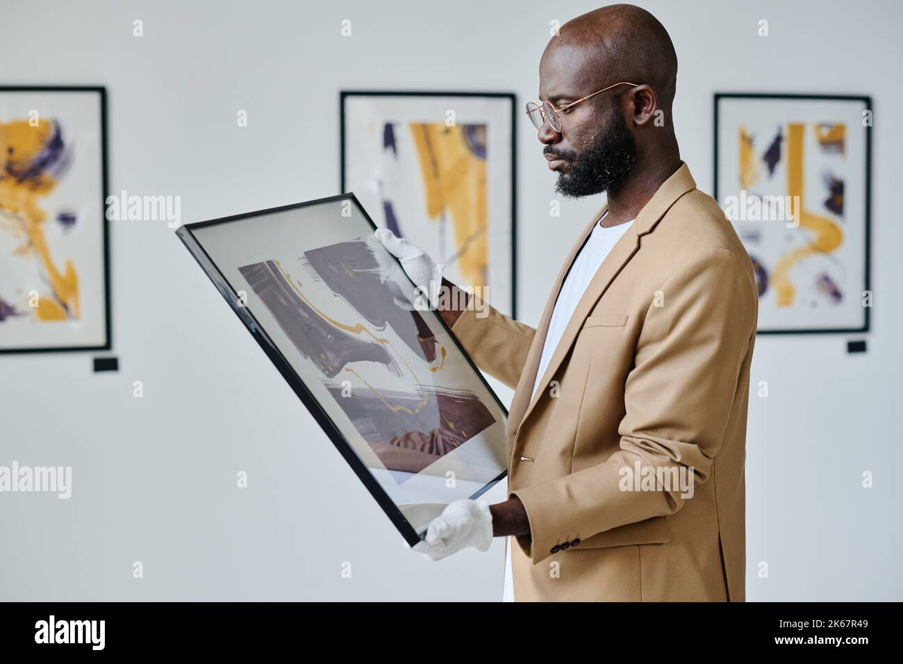 African guide examining modern art in his hands while working at art ...