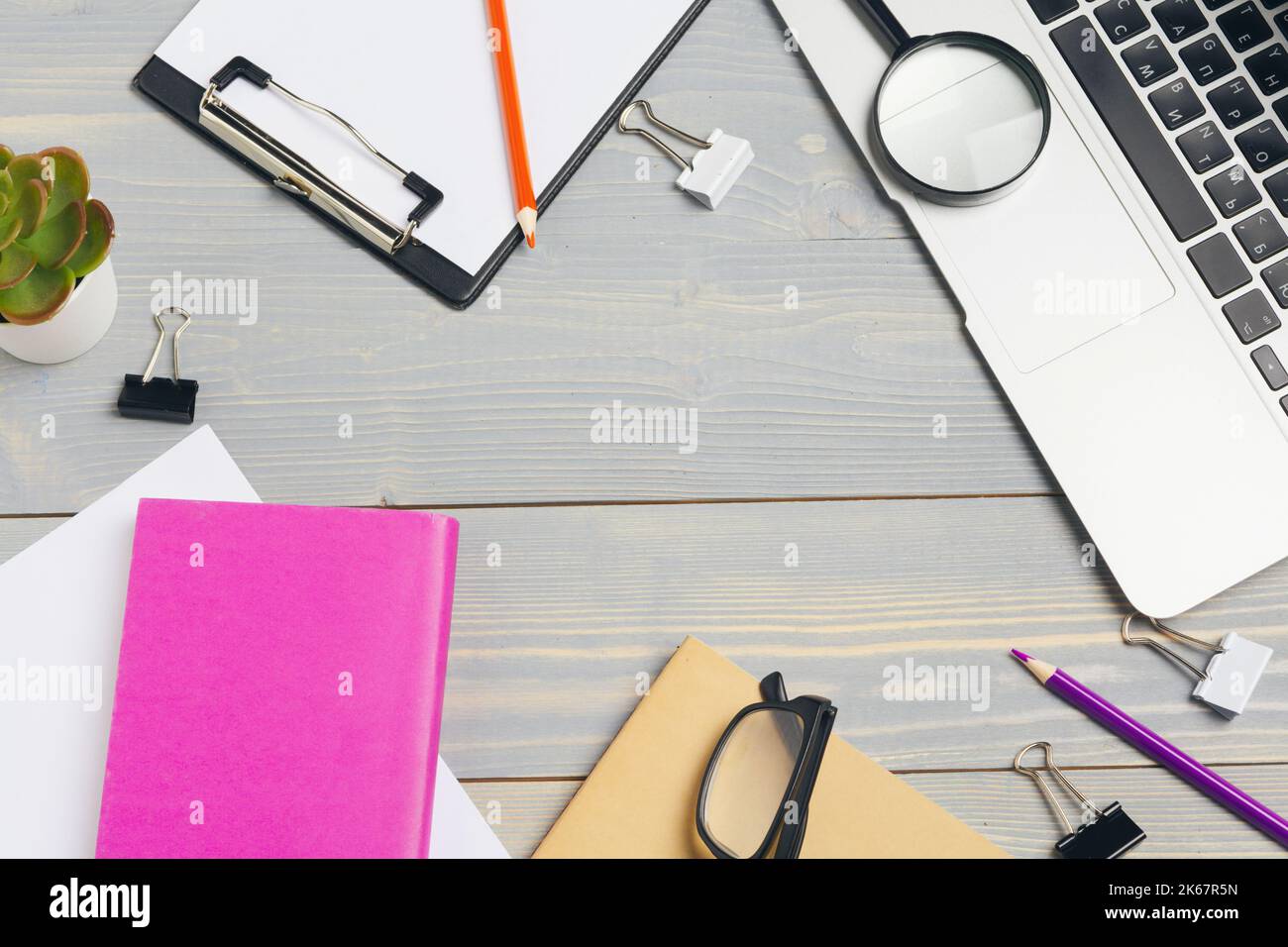 Top view of wooden desktop with glasses and stationery items close up ...