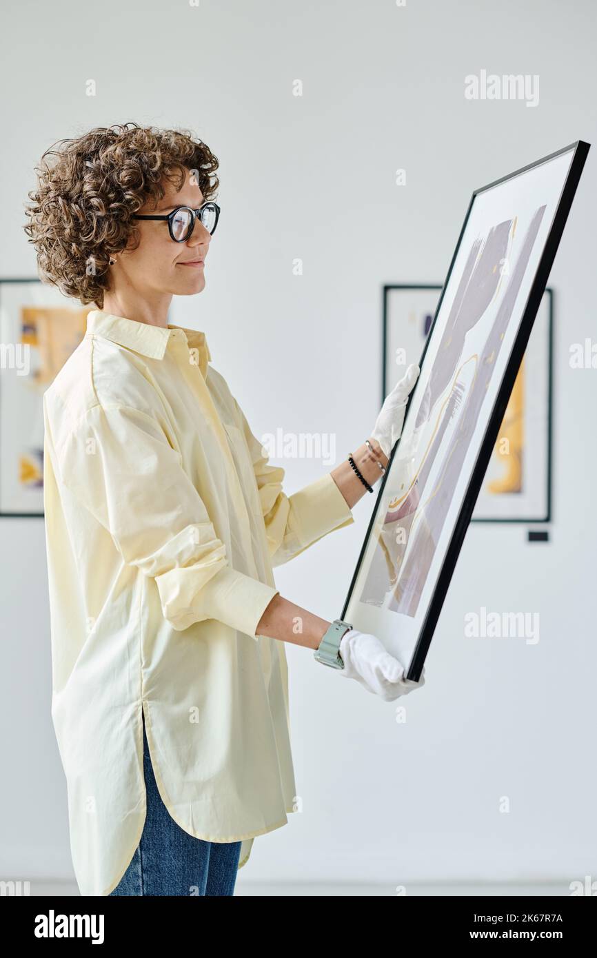 Gallery worker working with modern art in art gallery preparing for ...