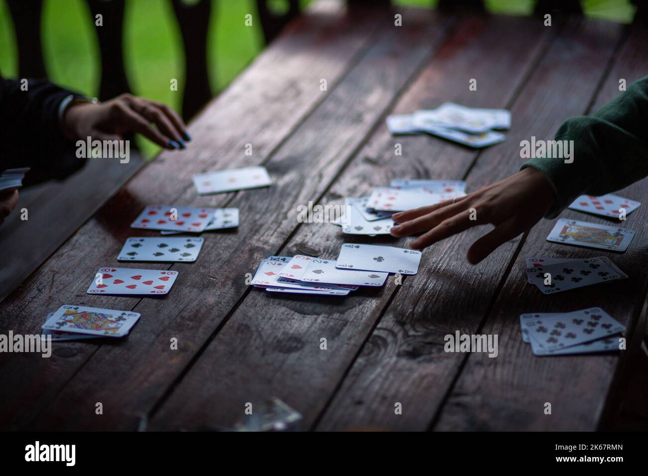 A two hands playing cards on the table Stock Photo - Alamy