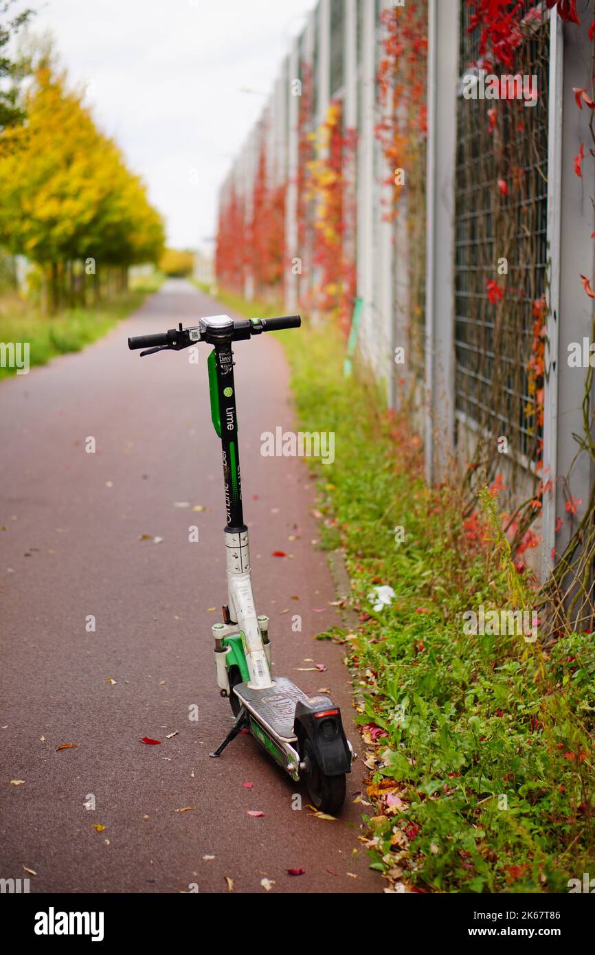 A vertical shot of the Lime brand rental electric scooter on a pathway ...
