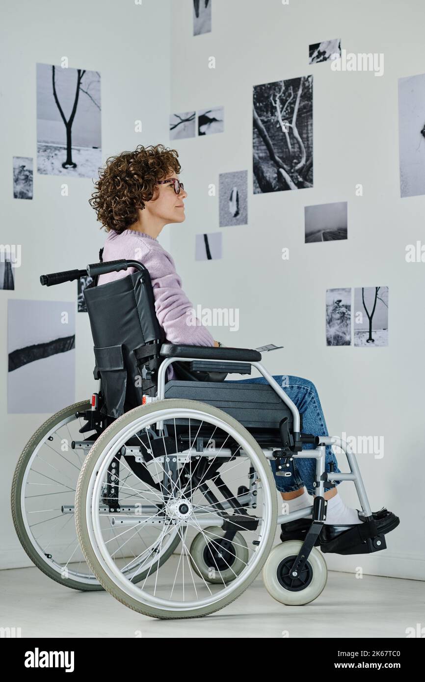 Young woman with disability visiting art exhibition at gallery of ...