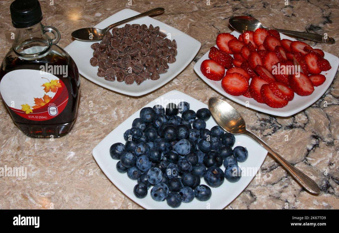 Fruit and chocolate chips and syrup for toppings on pancakes and ...