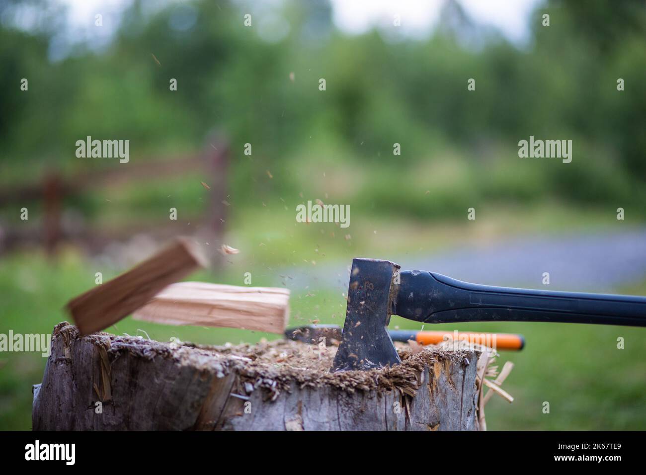 An axe splitting a wood with blurred background Stock Photo - Alamy