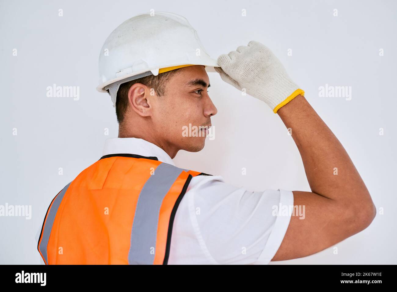 Portrait of an Asian construction worker tipping his hat facing right ...