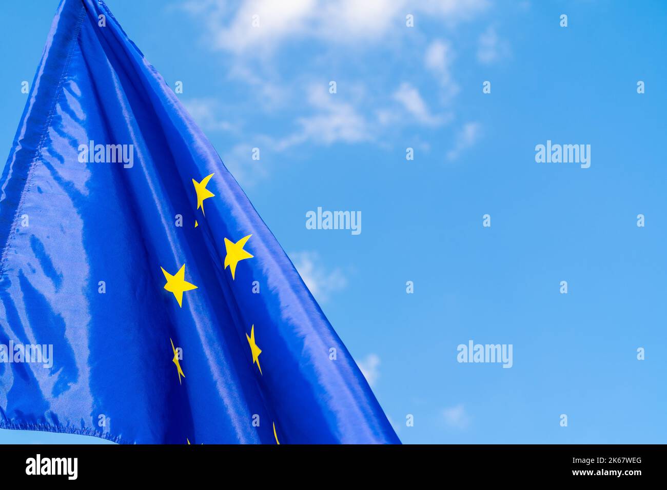 European Union flag against blue sky waving Stock Photo - Alamy