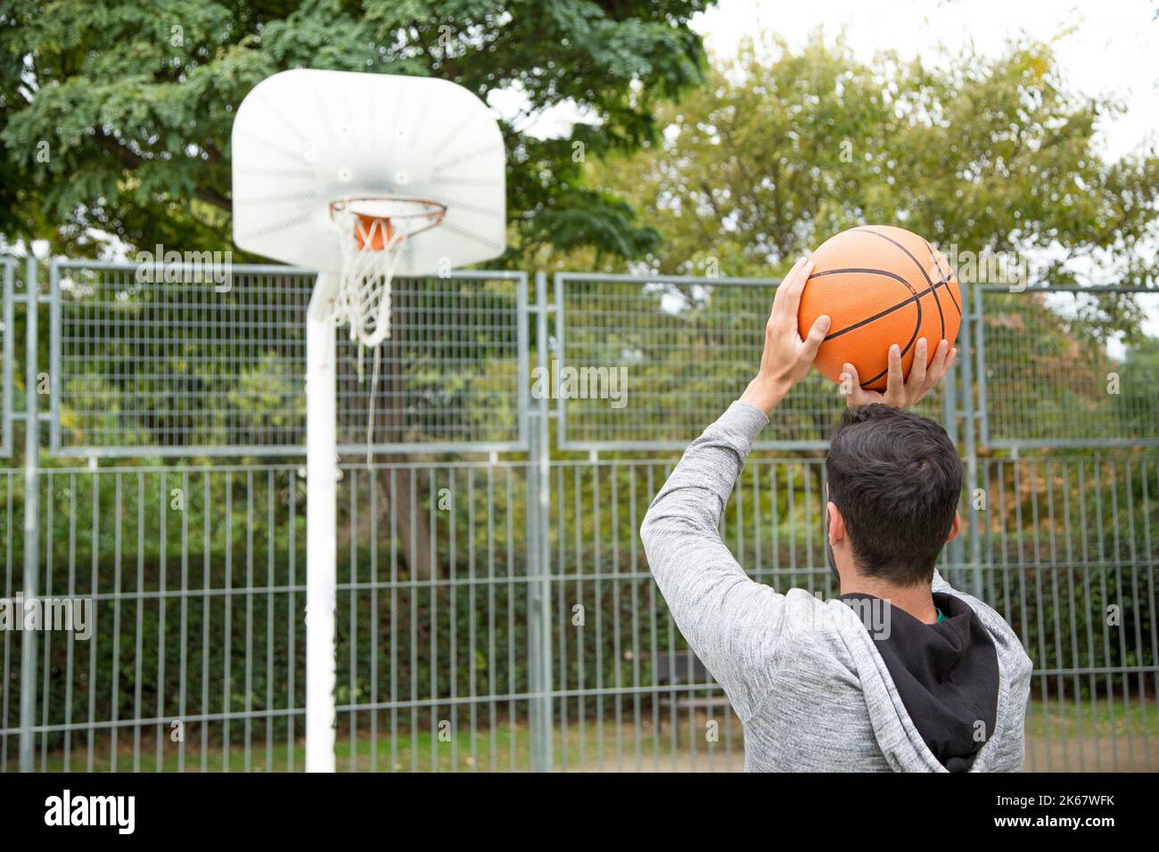 Rear view of a man throwing a three-pointer on a basketball court Stock ...