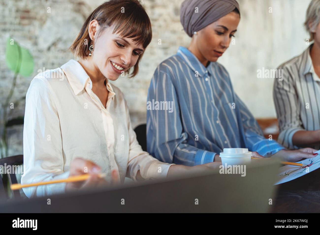 Multiethnic group of creative designer women team working o a project ...