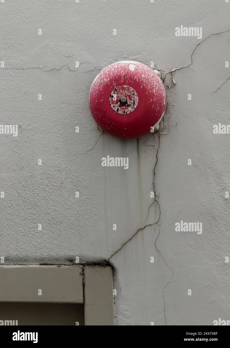 Old and dirty Red fire alarm bell on white concrete wall on top of ...