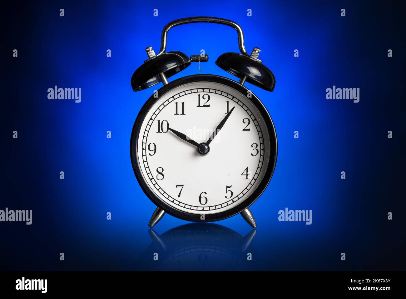 Alarm clock on blue background Stock Photo - Alamy
