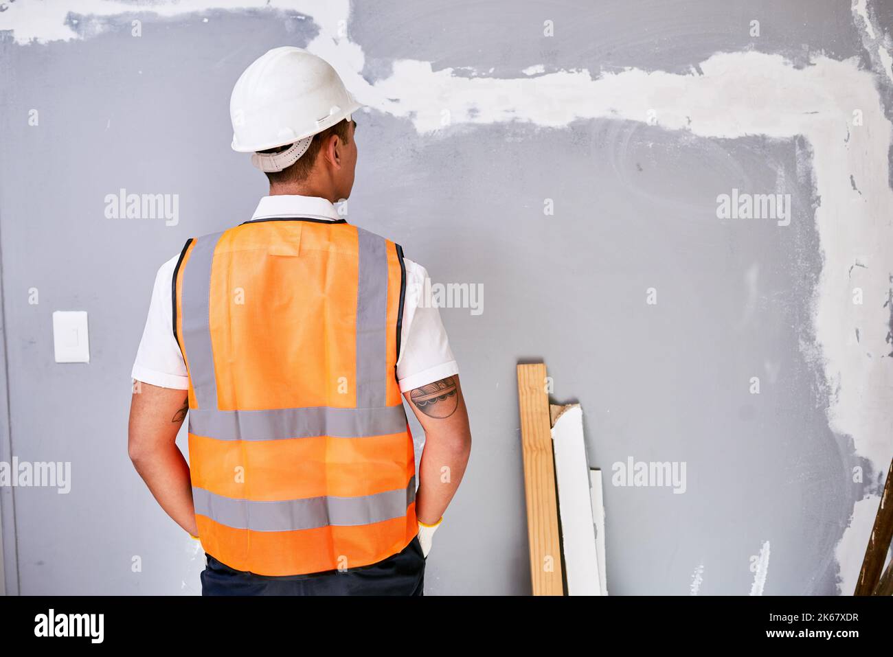 The back of a construction worker in uniform as he faces work in ...