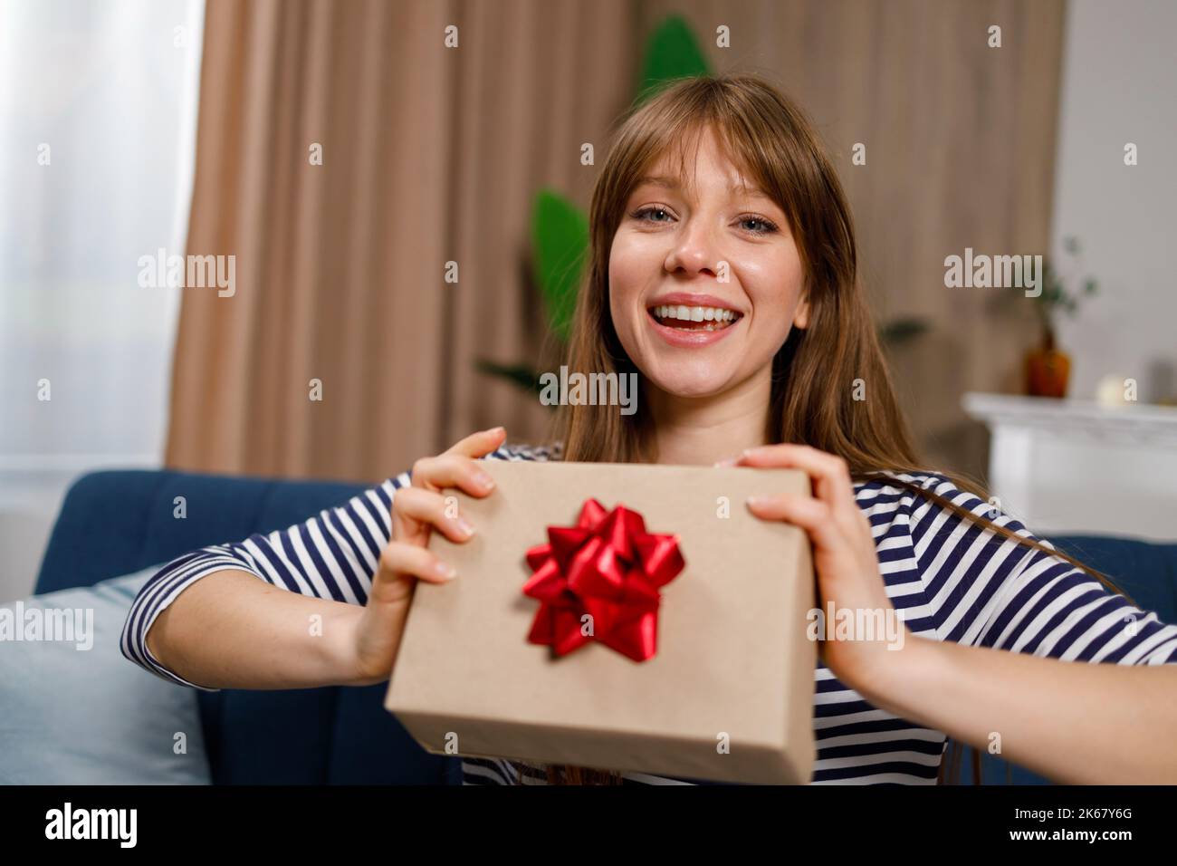 Portrait of a happy girl with a gift box in her hands indoor Stock ...
