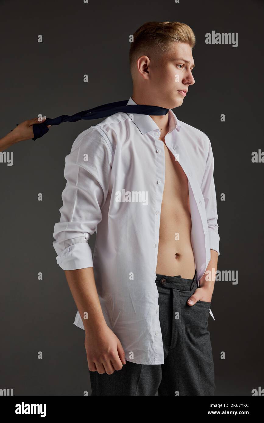 Portrait of young man in white shirt posing with serious expression ...