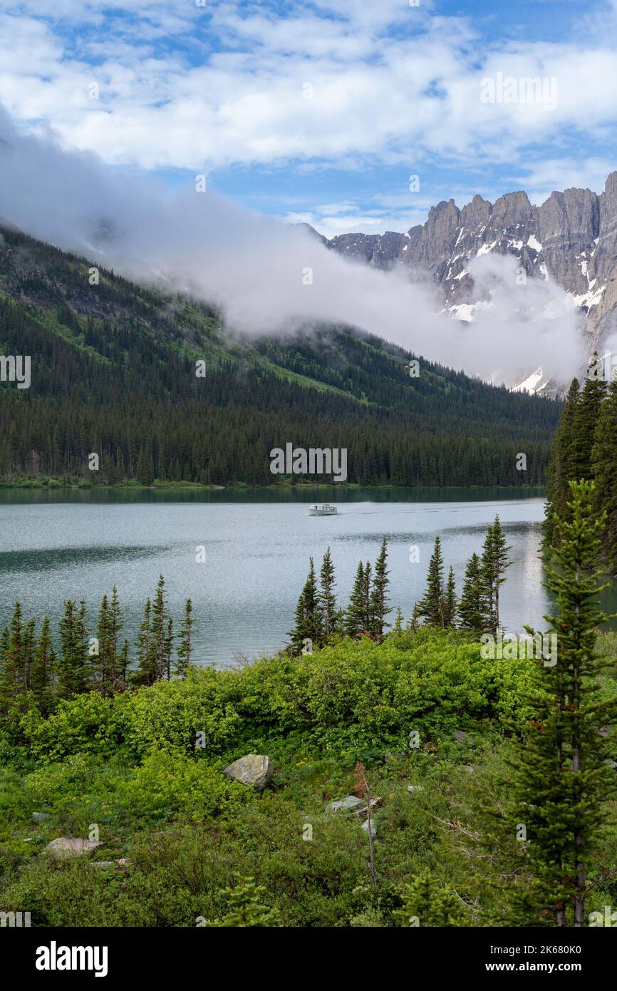 Lake Josephine in Glacier National Park as a boat passes by Stock Photo ...