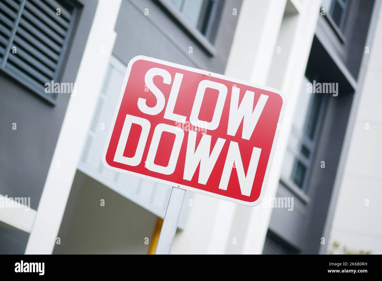 slow down sign against a building Stock Photo - Alamy