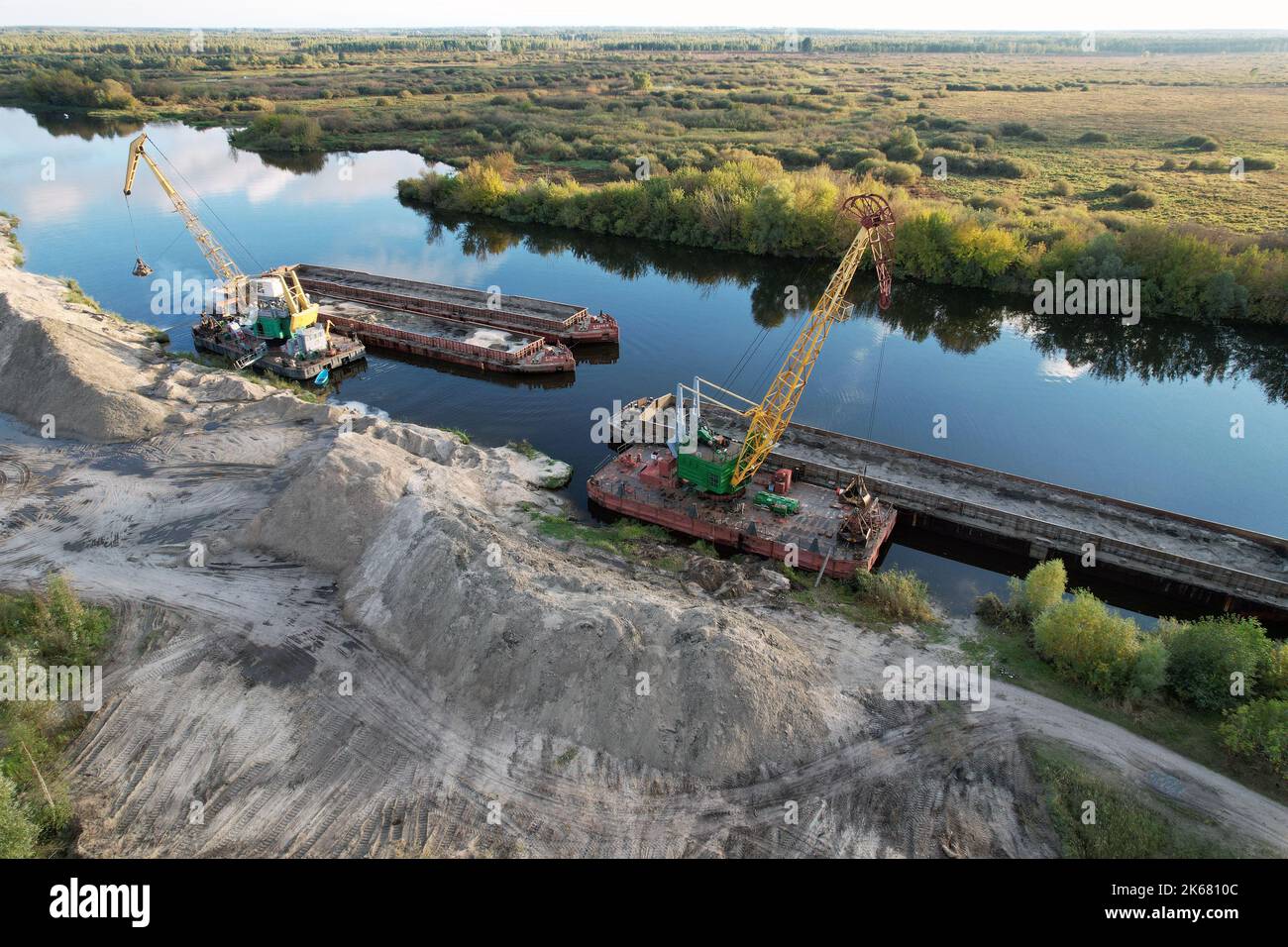 Large floating cranes unload bulk materials on the banks of the river ...