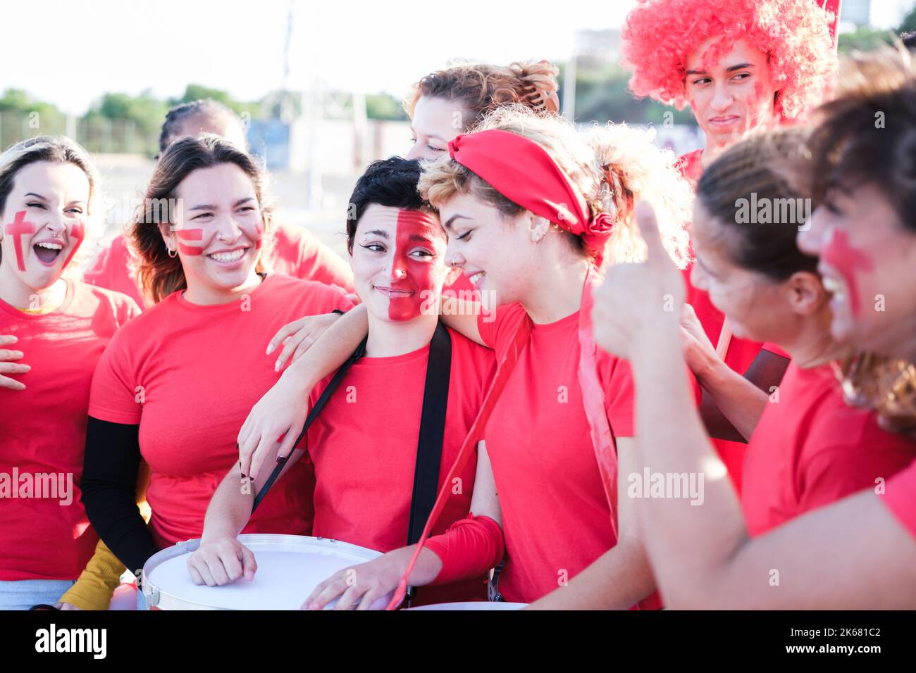 Embraced young women having a fun time cheering on their team before ...