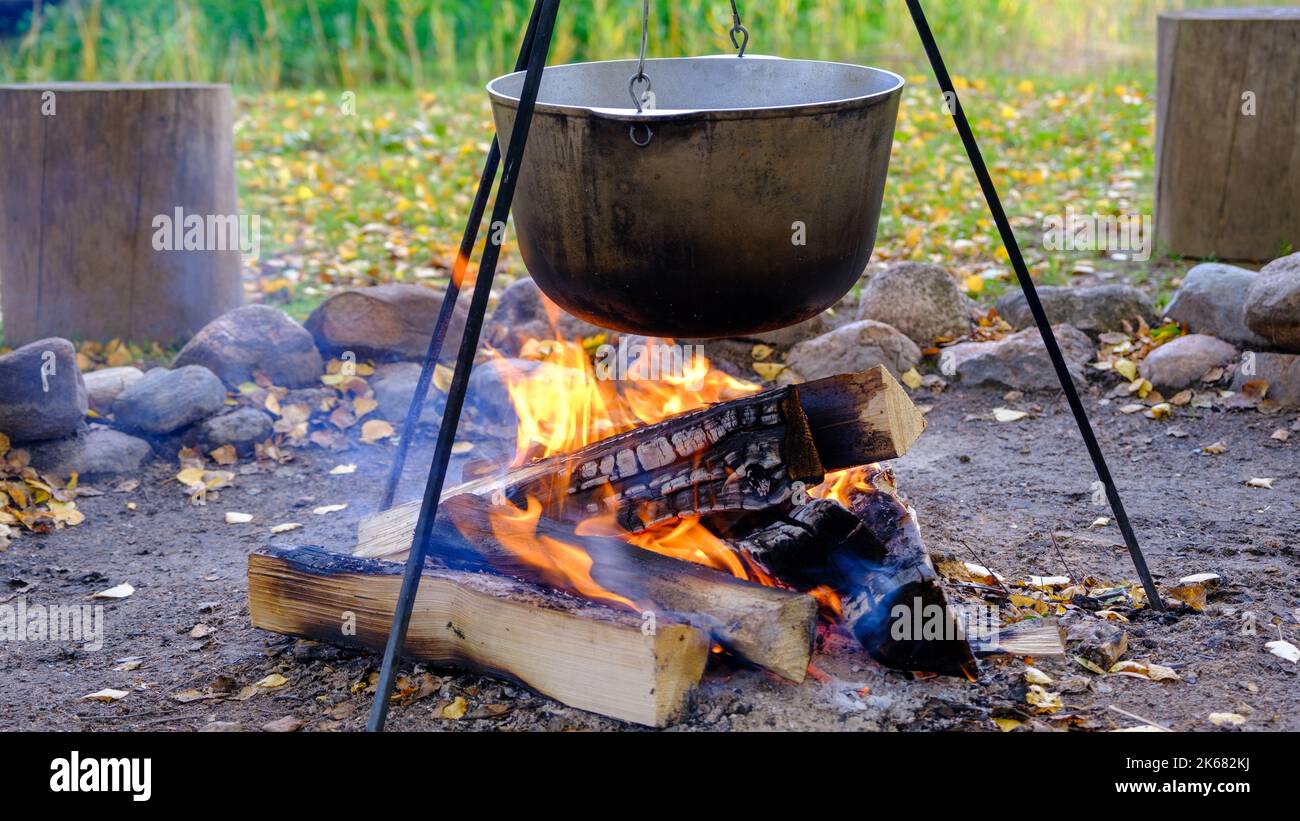 Cooking in a pot on an open fire in nature. Bowler on a bonfire in the ...