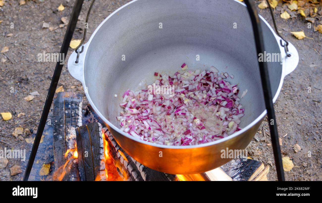 Cooking in a pot on an open fire in nature. Bowler on a bonfire in the ...
