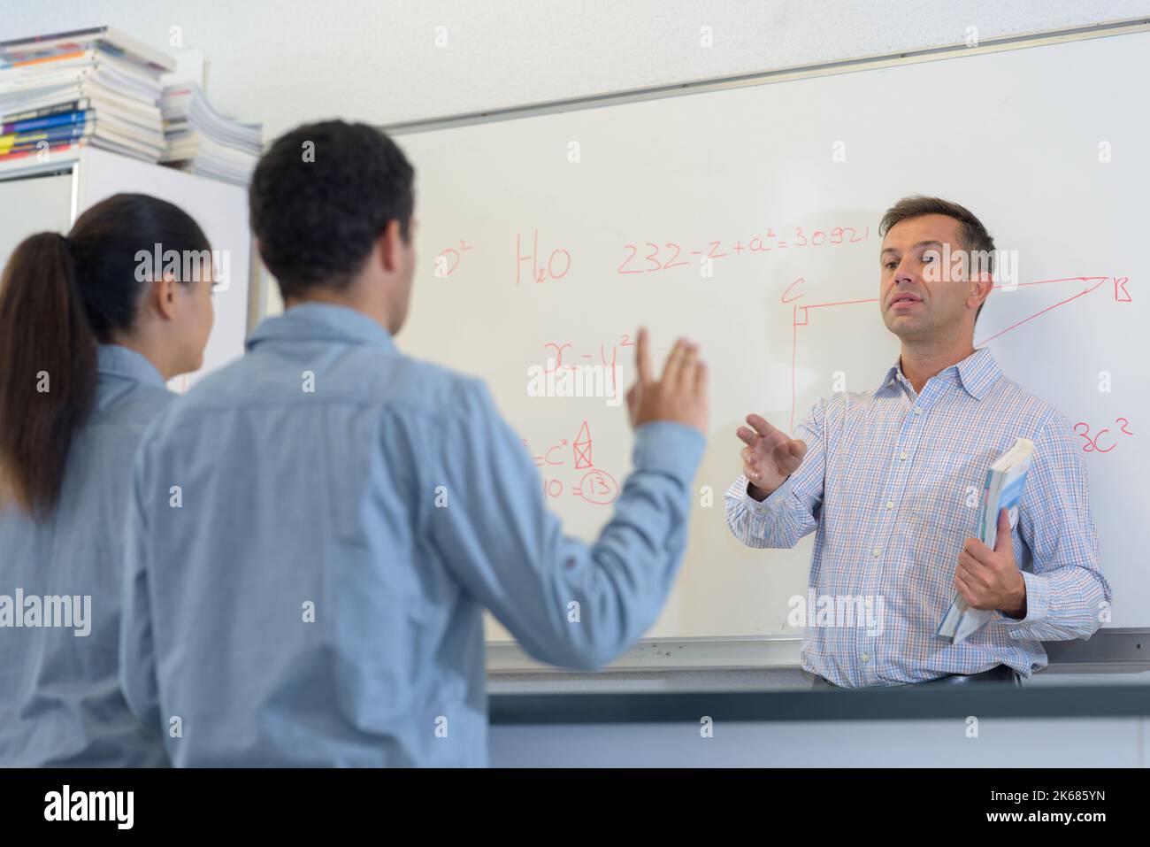 young students and teacher during tutoring lesson Stock Photo - Alamy