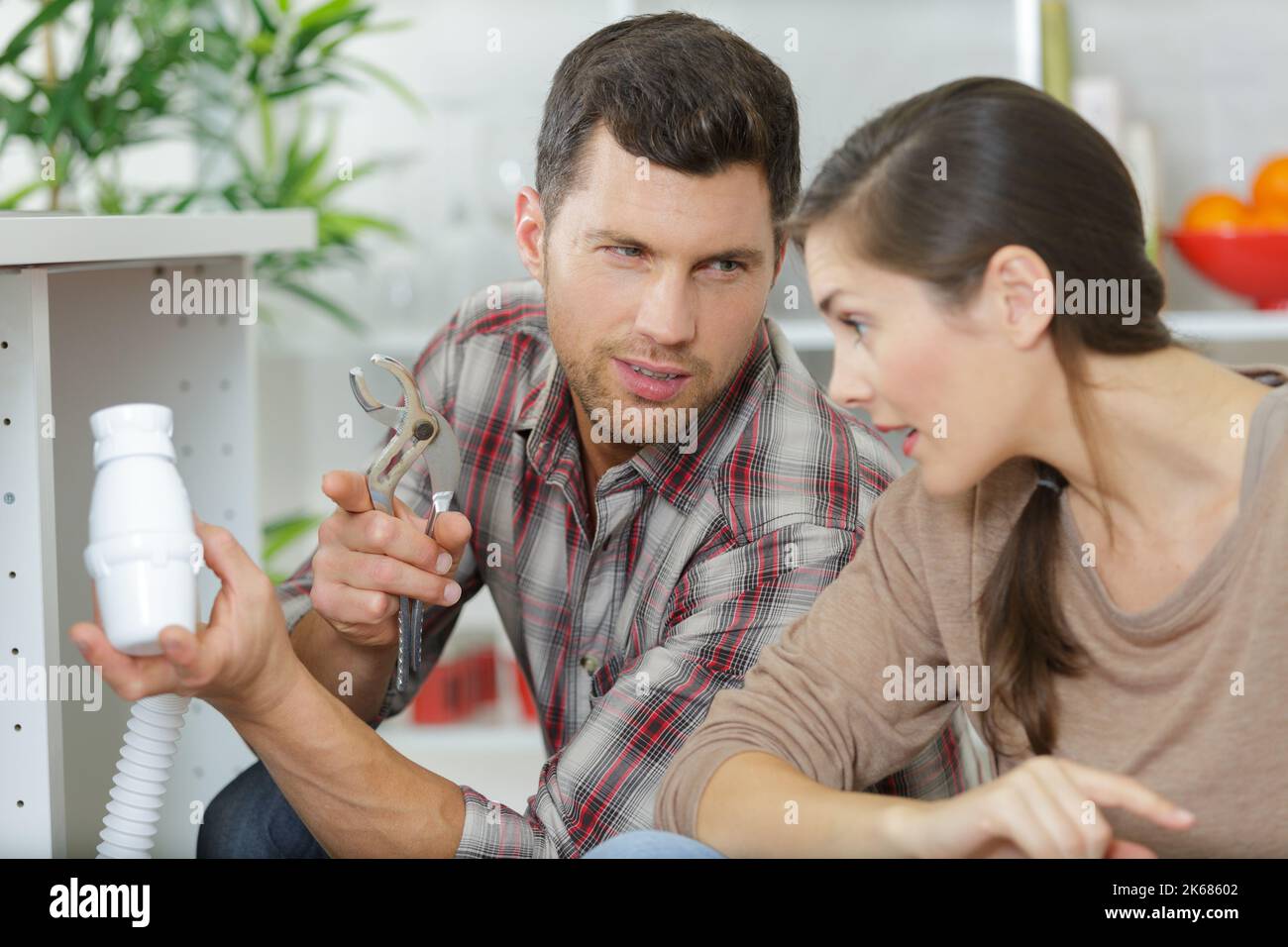 plumber showing female apprentice how to fit a kitchen sink Stock Photo ...