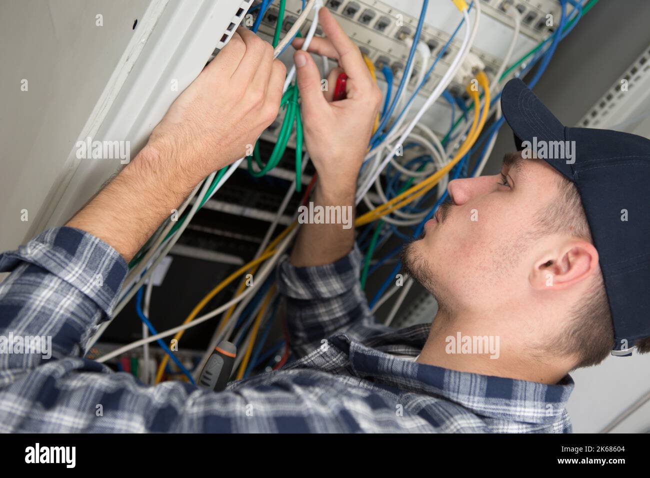 man connecting multiple color cables Stock Photo - Alamy