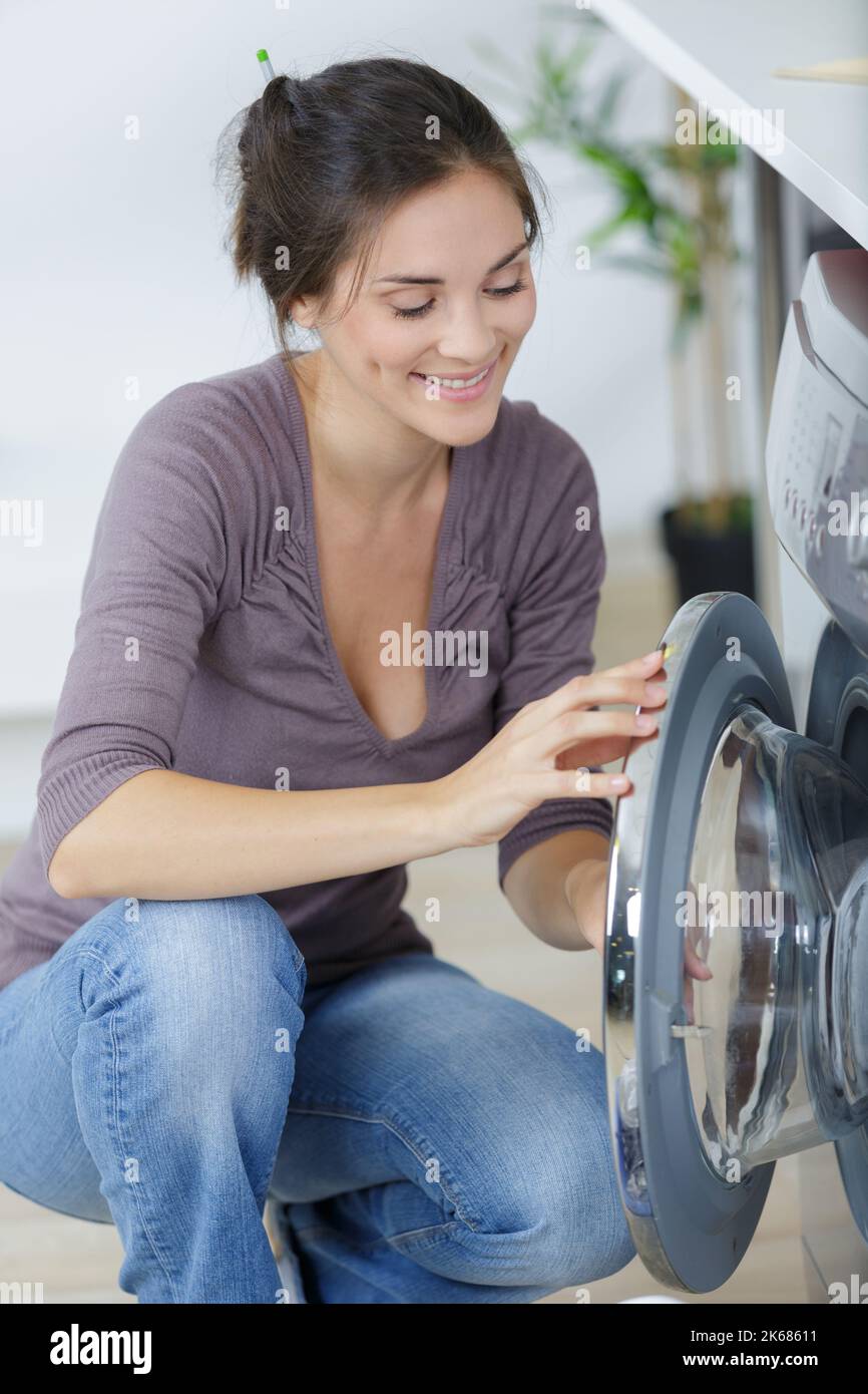 woman hand loading dirty clothes in washing machine Stock Photo - Alamy